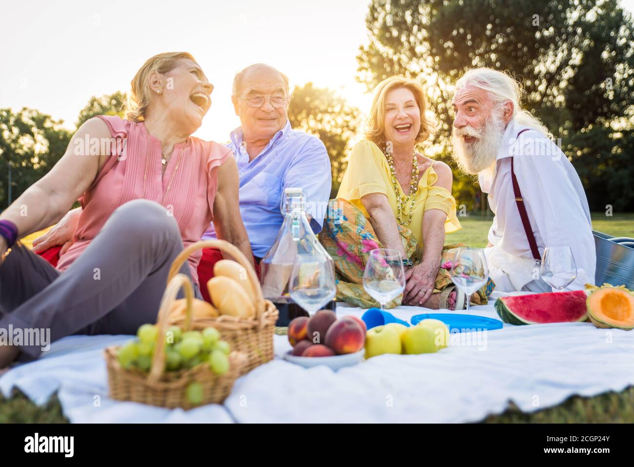 Group of youthful seniors having fun outdoors - Four pensioners bonding ...