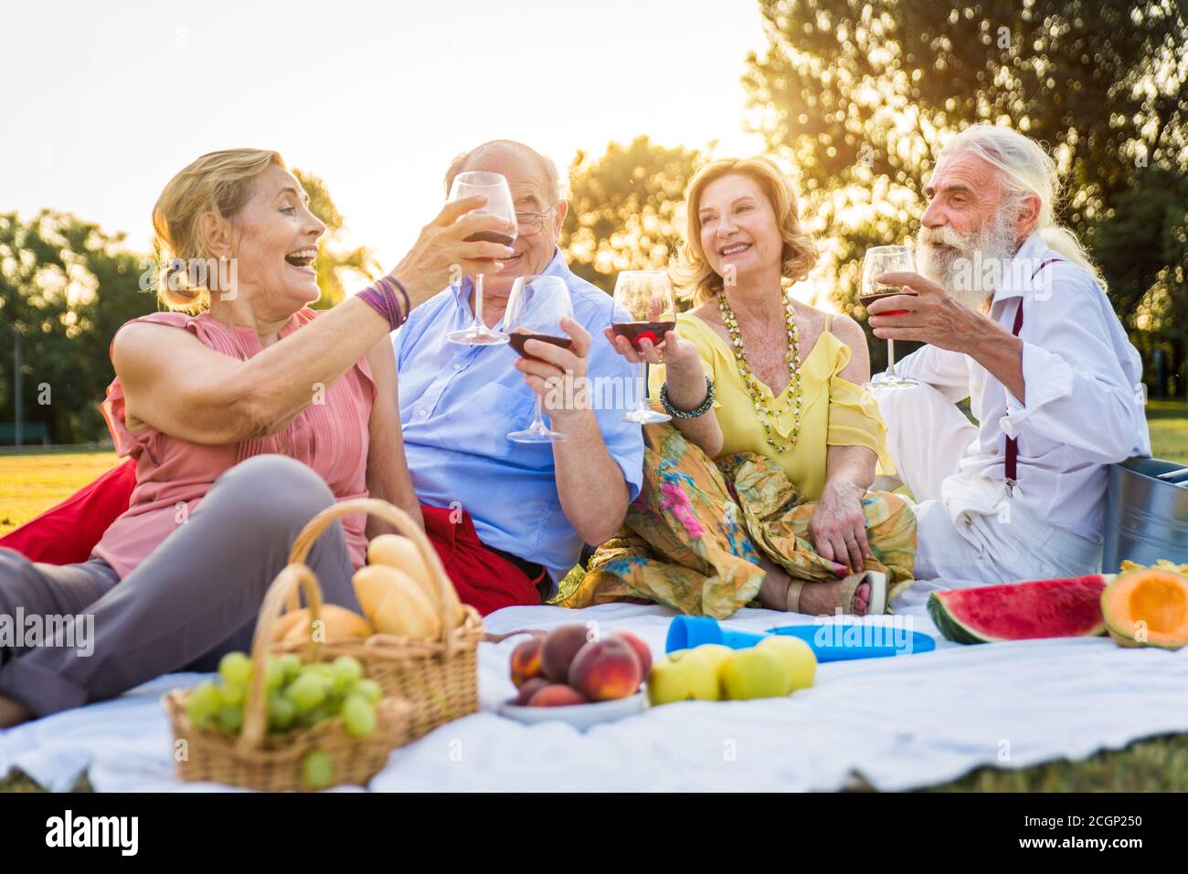 Group of youthful seniors having fun outdoors - Four pensioners bonding ...