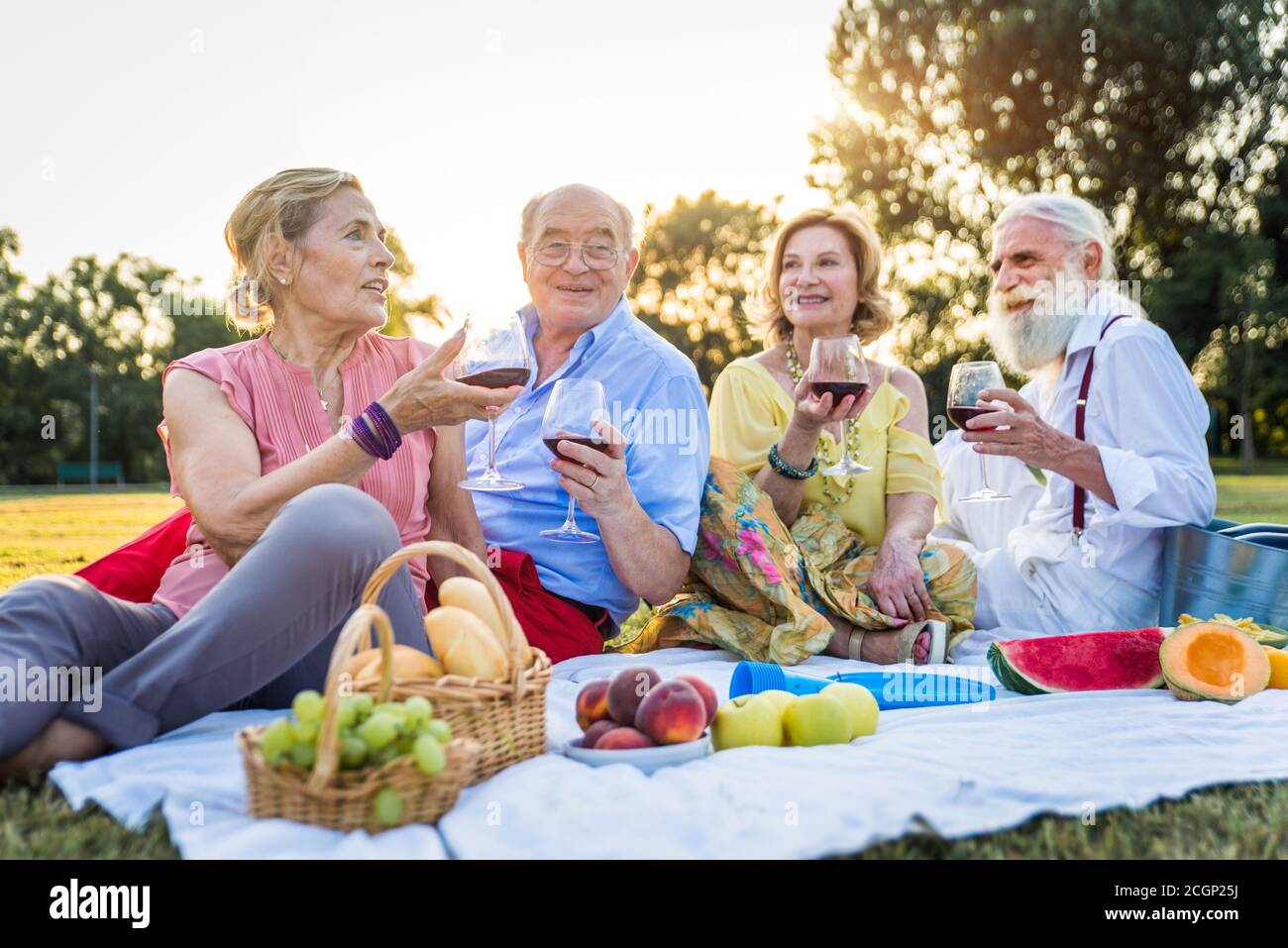 Group of youthful seniors having fun outdoors - Four pensioners bonding ...