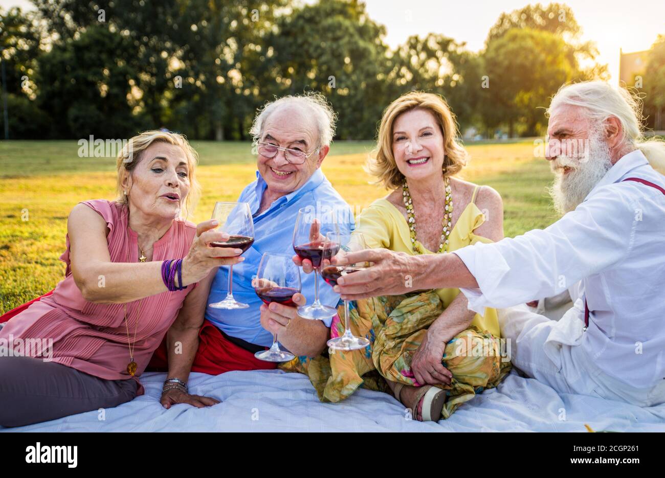 Group of youthful seniors having fun outdoors - Four pensioners bonding ...