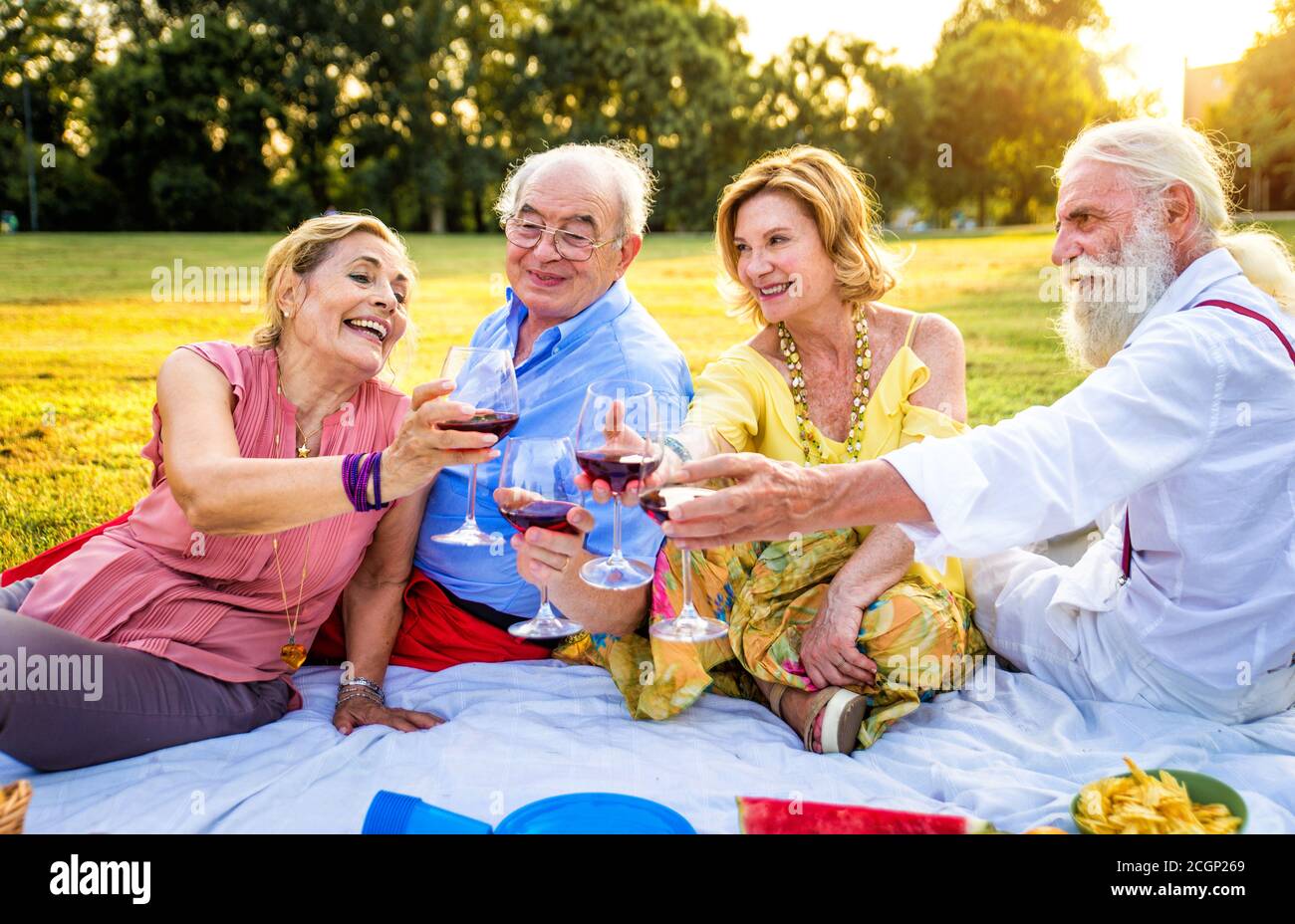 Group of youthful seniors having fun outdoors - Four pensioners bonding ...