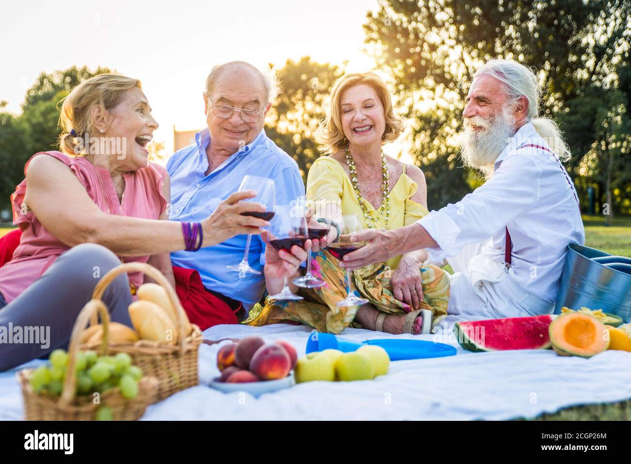 Group of youthful seniors having fun outdoors - Four pensioners bonding ...