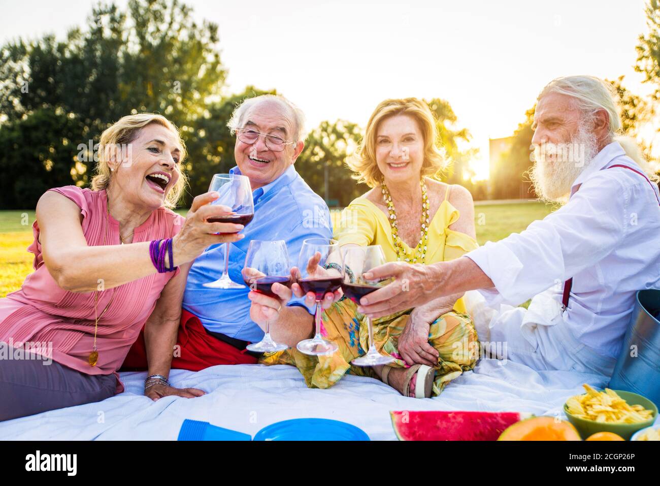 Group of youthful seniors having fun outdoors - Four pensioners bonding ...