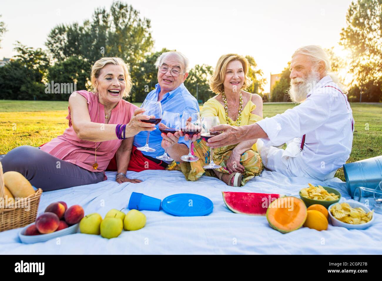 Group of youthful seniors having fun outdoors - Four pensioners bonding ...