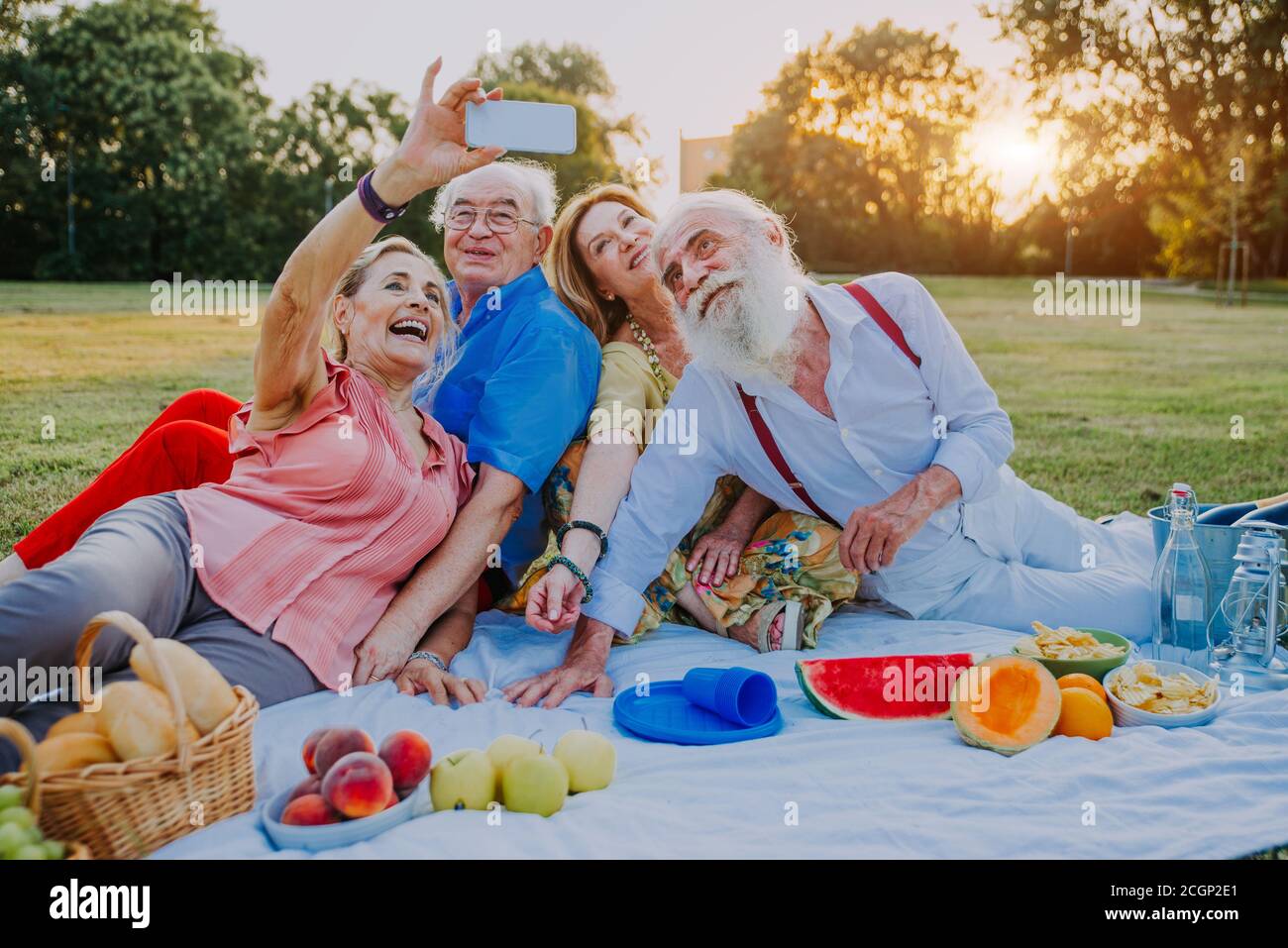Group of youthful seniors having fun outdoors - Four pensioners bonding ...