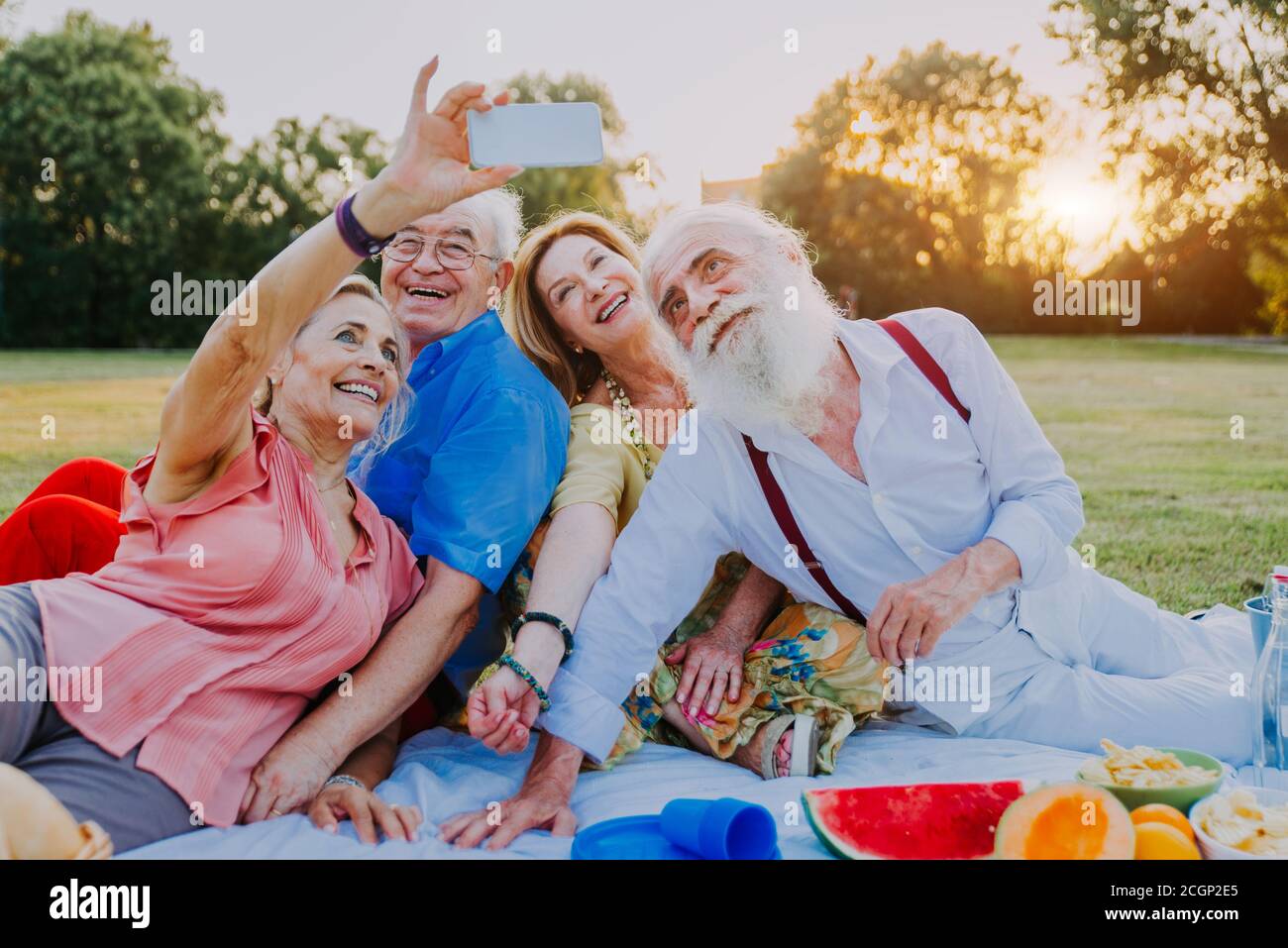 Group of youthful seniors having fun outdoors - Four pensioners bonding ...