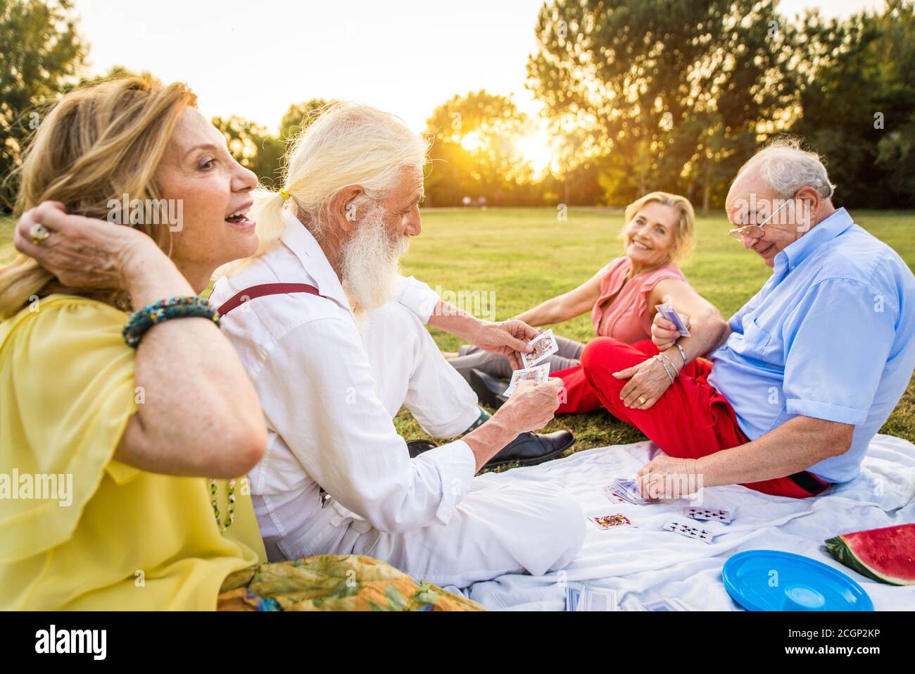 Group of youthful seniors having fun outdoors - Four pensioners bonding ...