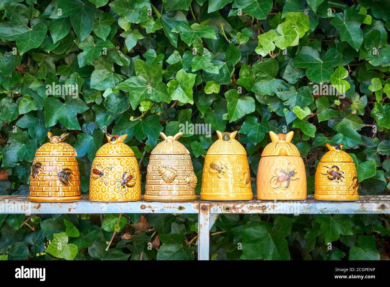 A row of vintage yellow glazed honeypots in the form of beehives in a ...