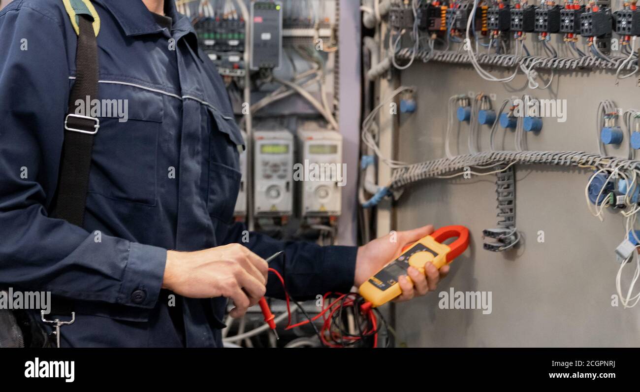 Worker engineer checks electrician measurements with tester multimeter ...