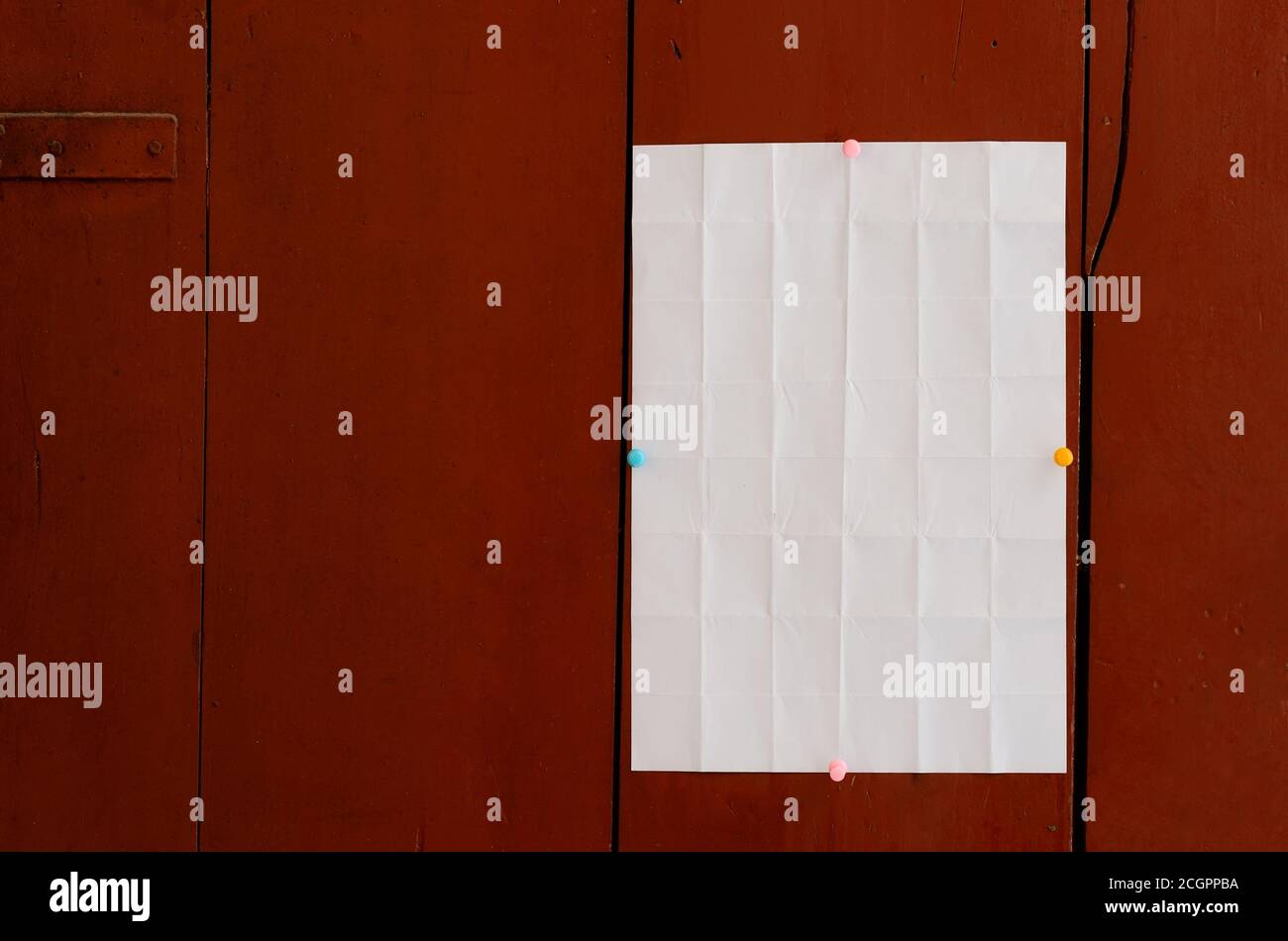 Sheet of wrinkled paper attached to an old painted door. For empty and ...