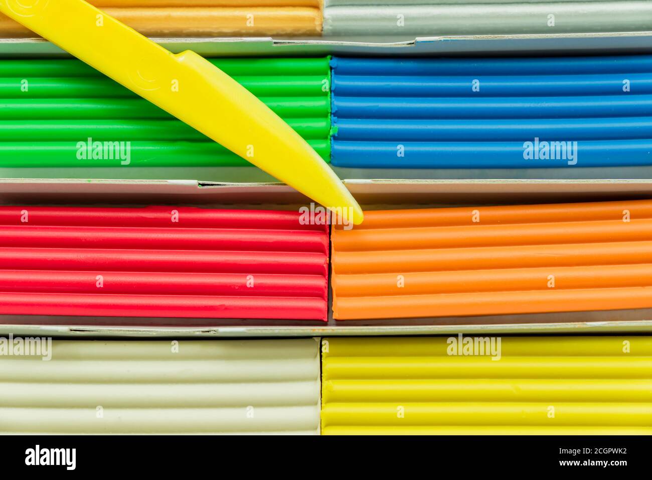 Set of multicolored plasticine bars for modeling in paper box. Top view ...