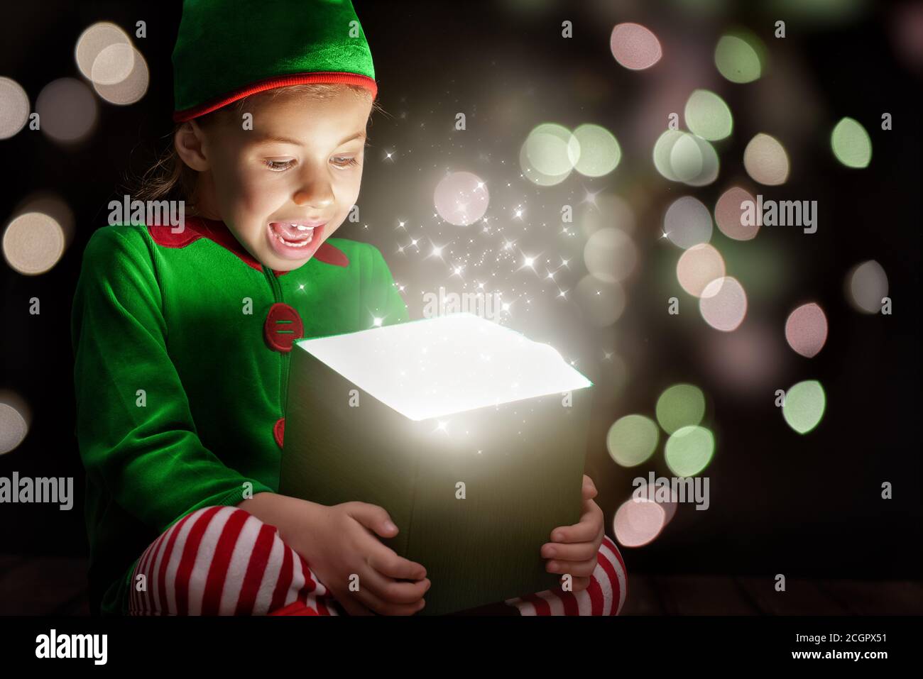 Cute little girl opening a magic gift box Stock Photo - Alamy