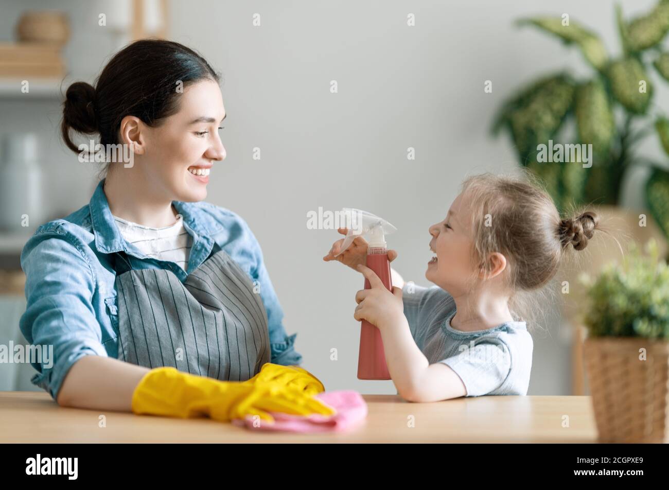 Happy family at home. Mother and daughter doing the cleaning in the ...