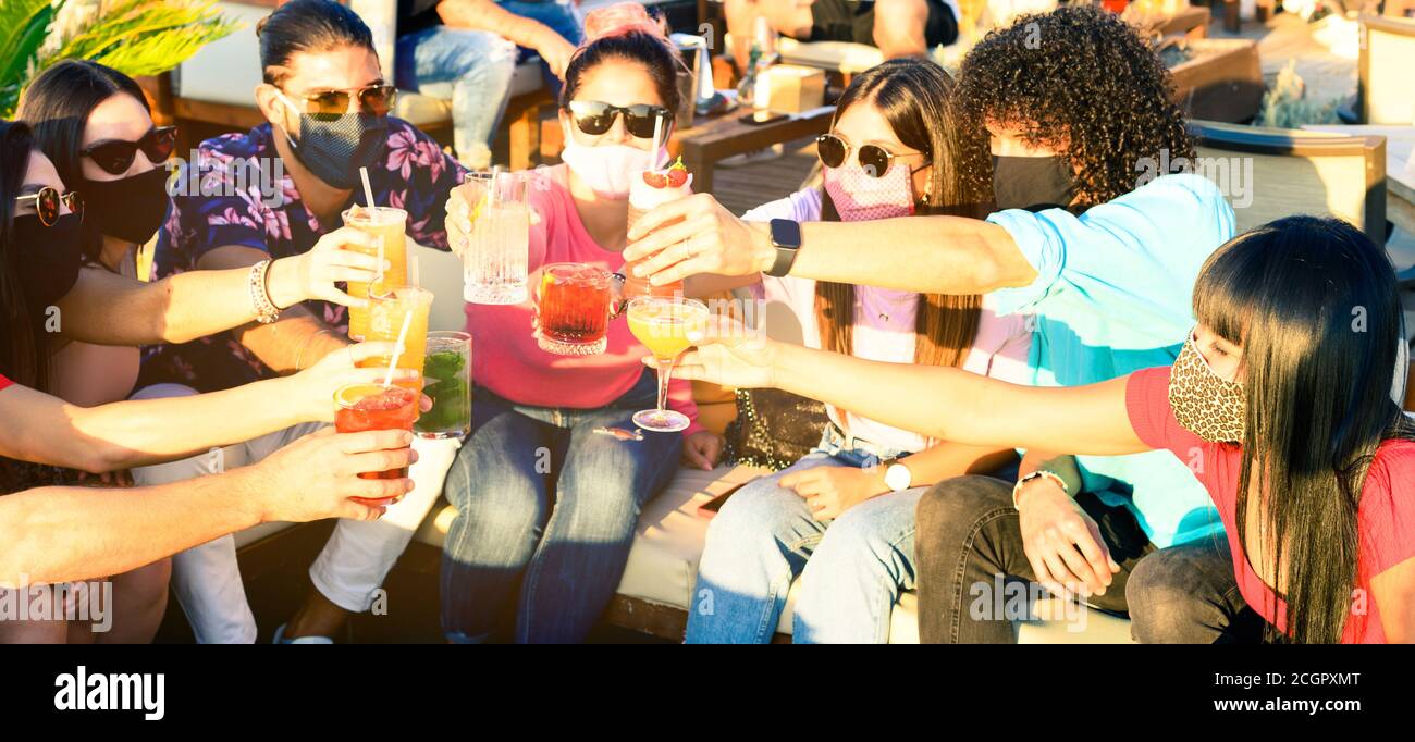 Friends drinking cocktail at bar with face masks - Friendship concept ...