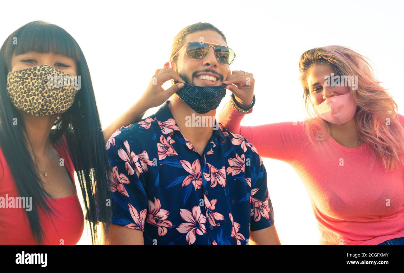Two happy young women take off protective mask at boy - Young man smile ...
