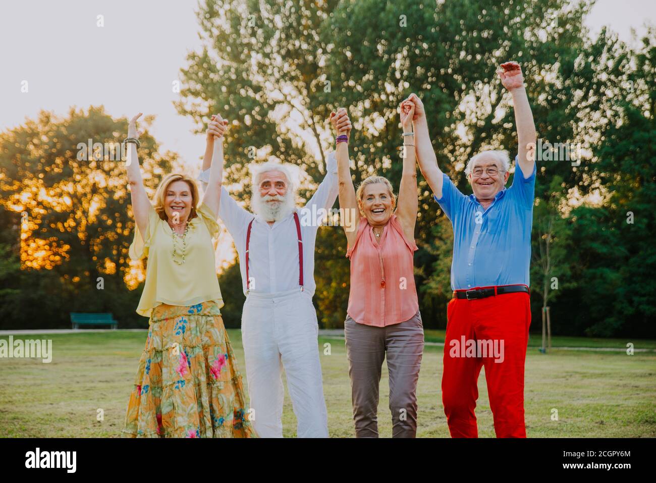 Group of youthful seniors having fun outdoors - Four pensioners bonding ...