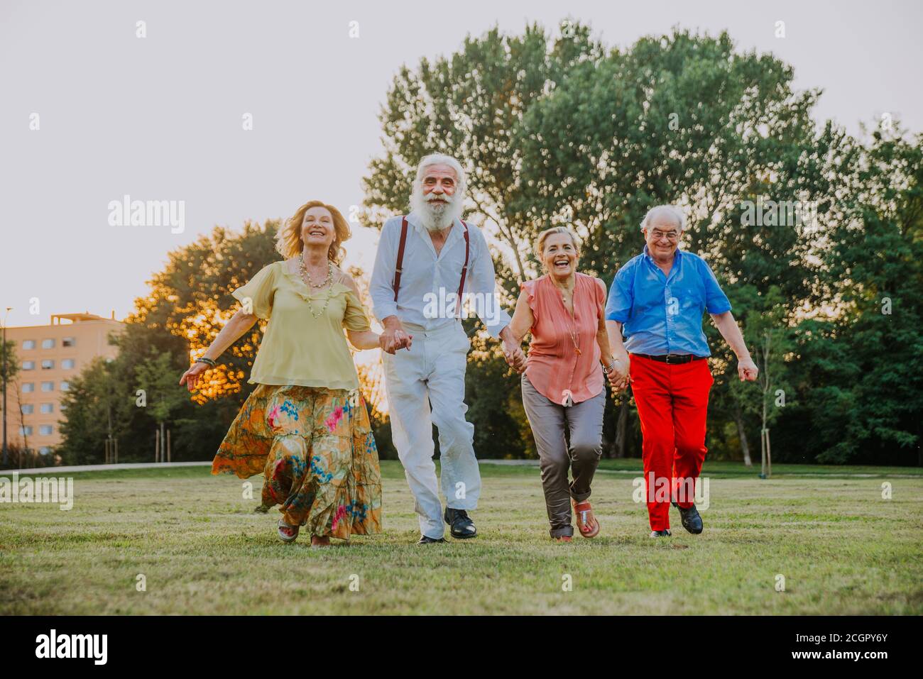 Group of youthful seniors having fun outdoors - Four pensioners bonding ...