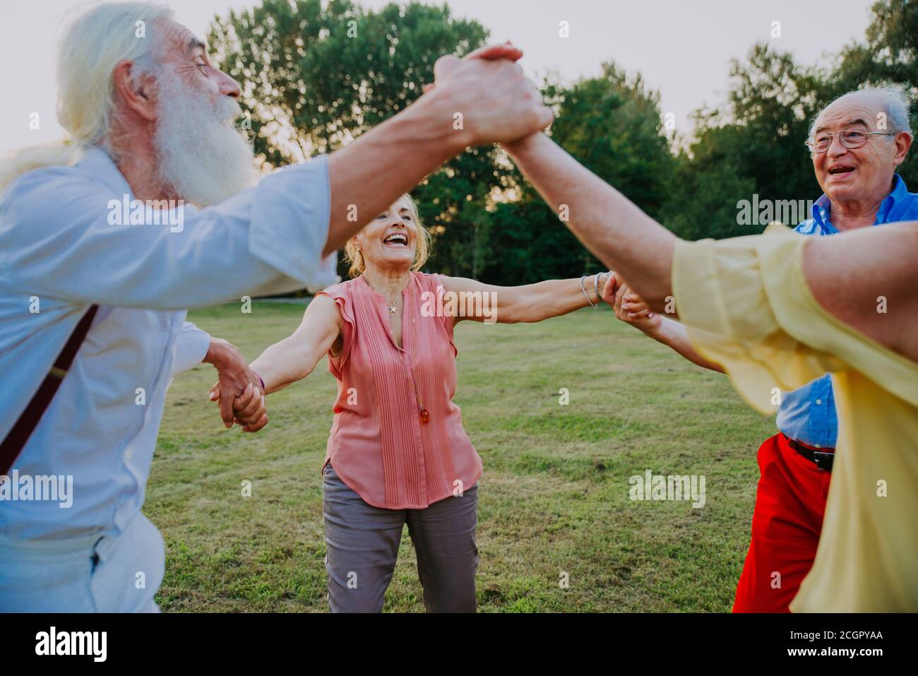 Group of youthful seniors having fun outdoors - Four pensioners bonding ...