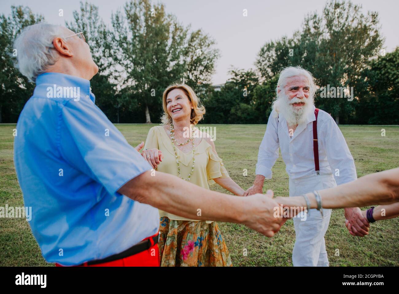 Group of youthful seniors having fun outdoors - Four pensioners bonding ...