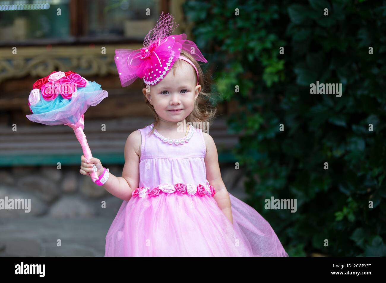 .Brides parade.Beautiful little girl in a pink dress with a bouquet of ...