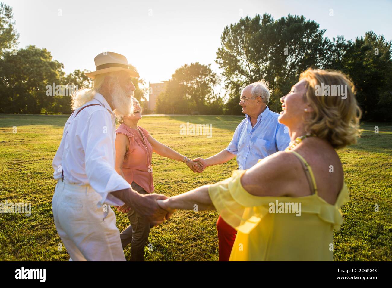 Group of youthful seniors having fun outdoors - Four pensioners bonding ...