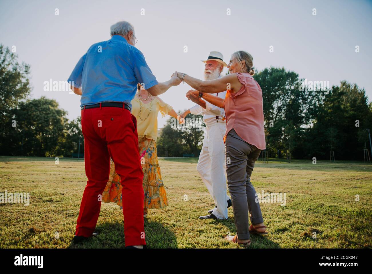 Group of youthful seniors having fun outdoors - Four pensioners bonding ...