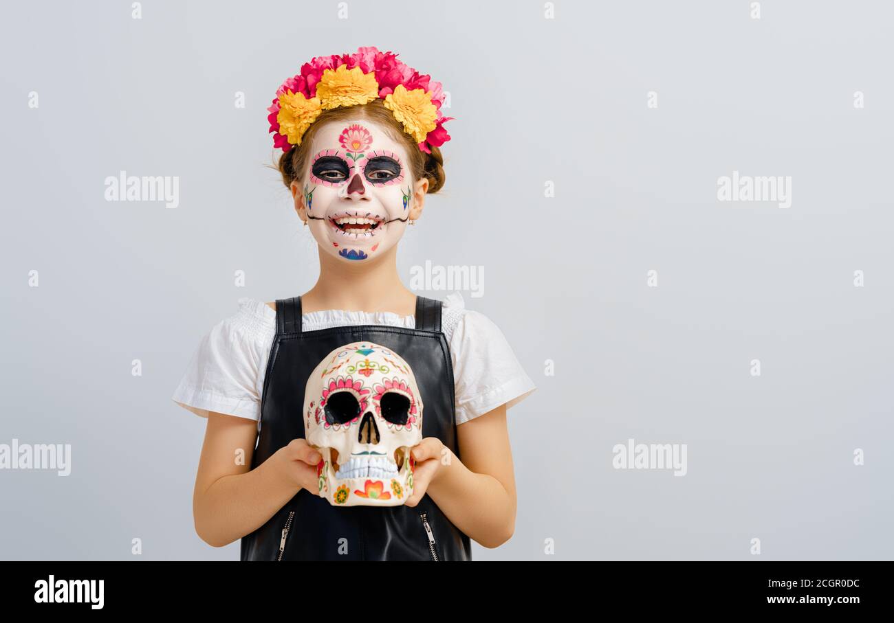 Adorable zombie in flower wreath posing on grey background. Happy child ...