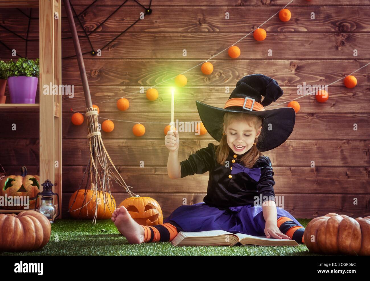 Happy Halloween! Cute cheerful little witch with a magic wand and book ...