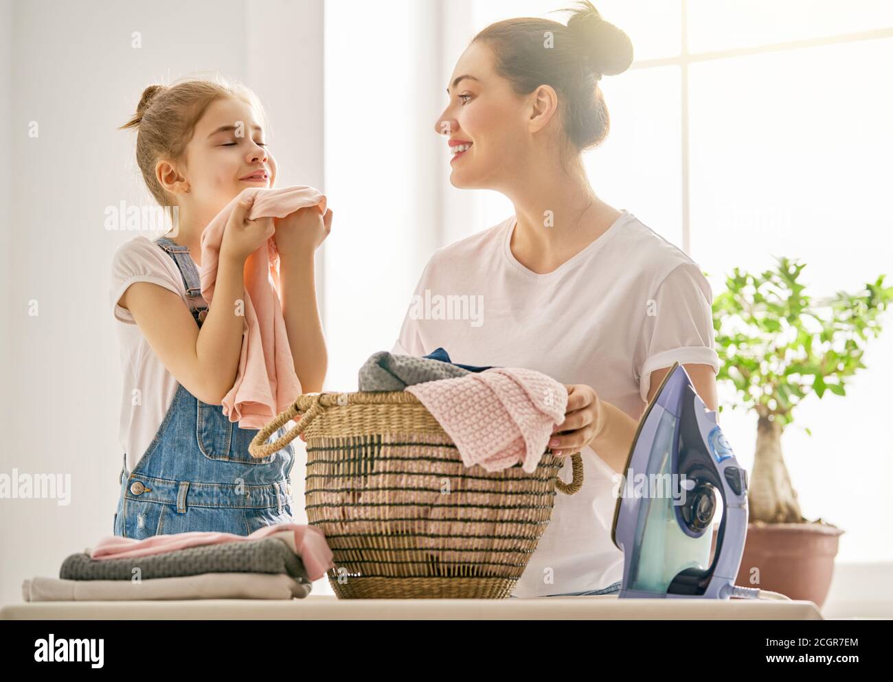 Beautiful young woman and child girl little helper are having fun and ...