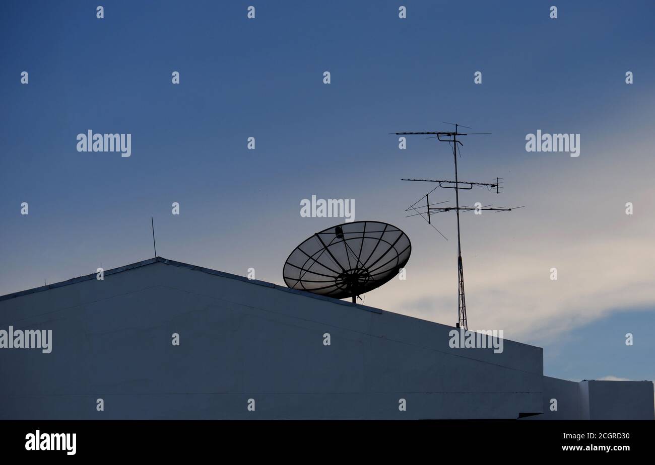 Satellite dish receivers above building roofs, communication technology ...