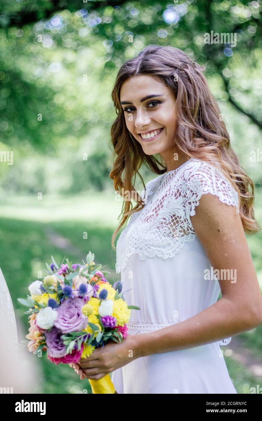 Wedding scene - bride with flower bouquet outdoor Stock Photo - Alamy