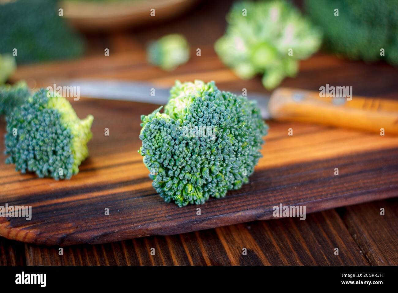Fresh broccoli cutted on the kitchen board by knife Stock Photo - Alamy