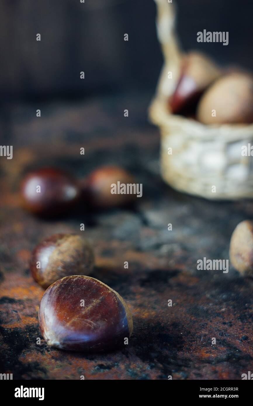 Fresh chestnuts in basket over black rustic surface Stock Photo - Alamy