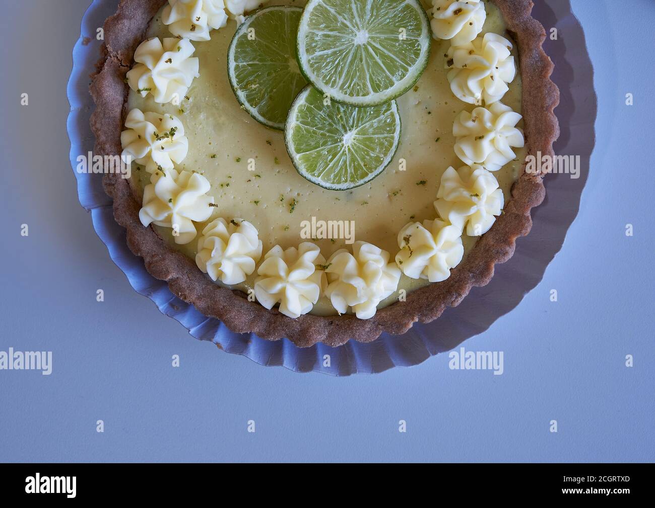 key lime pie. lime pie and whipped cream with sablé dough and garnished ...