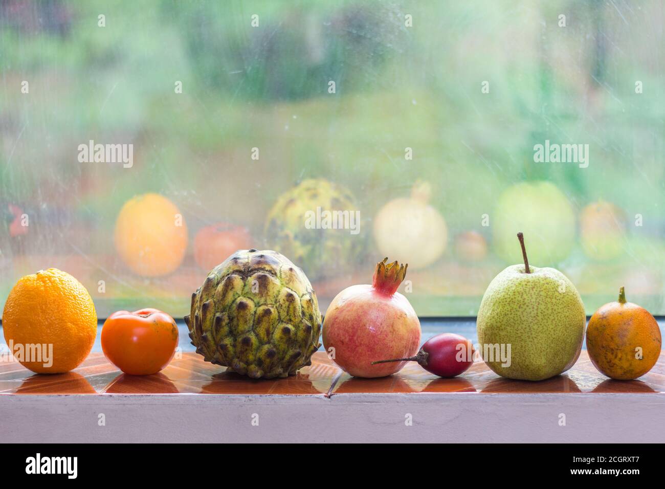 Different fruits at a window sill Stock Photo - Alamy