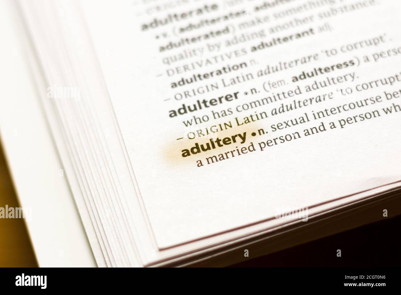 The word or phrase Adultery in a dictionary highlighted with marker ...