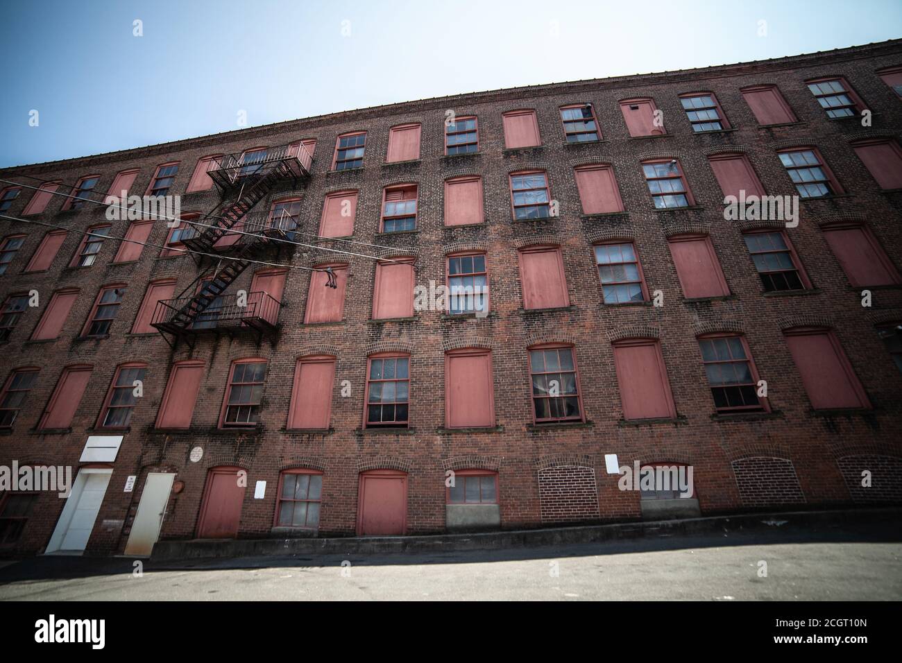Large five-story redbrick building, some windows nailed up, three fire ...