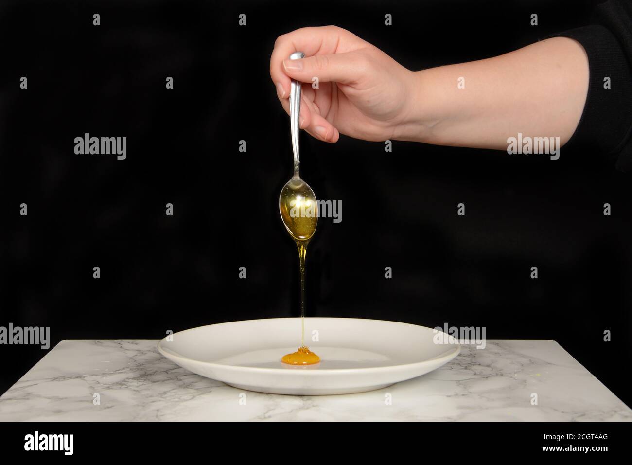Syrup falling off a spoon Stock Photo - Alamy