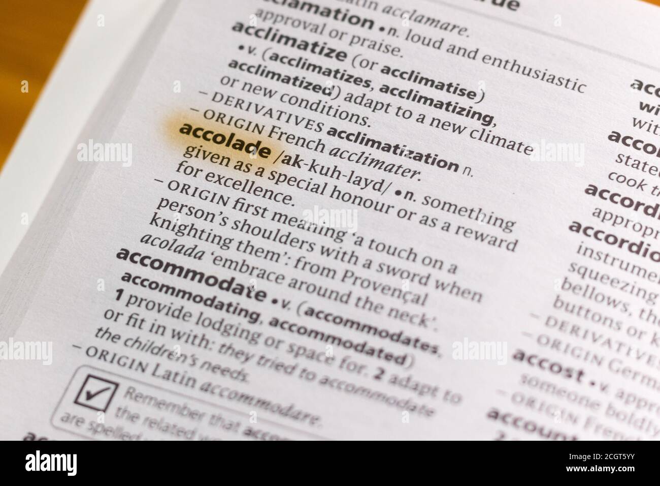 The word or phrase Accolade in a dictionary highlighted with marker ...