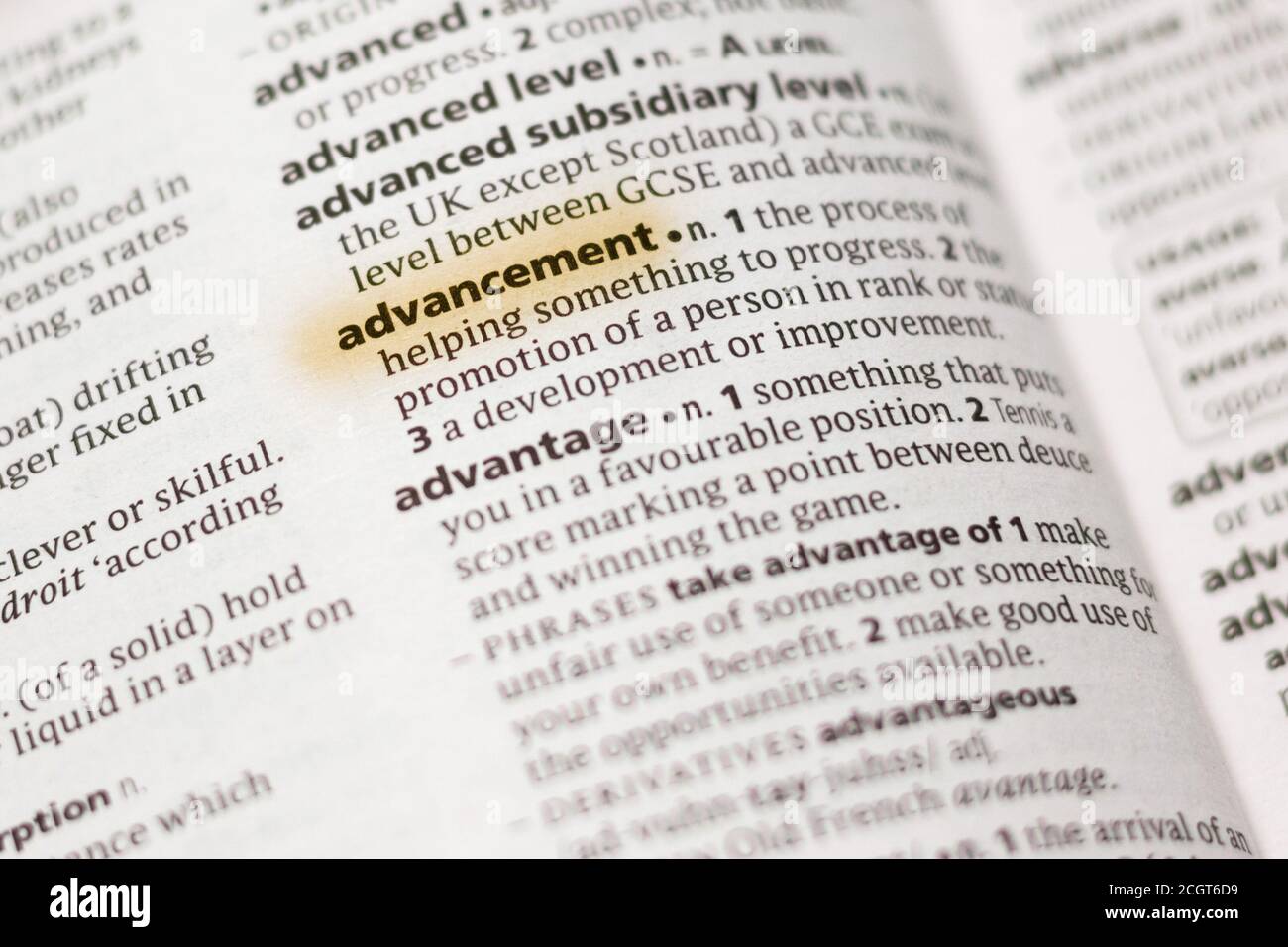 The word or phrase Advancement in a dictionary highlighted with marker ...