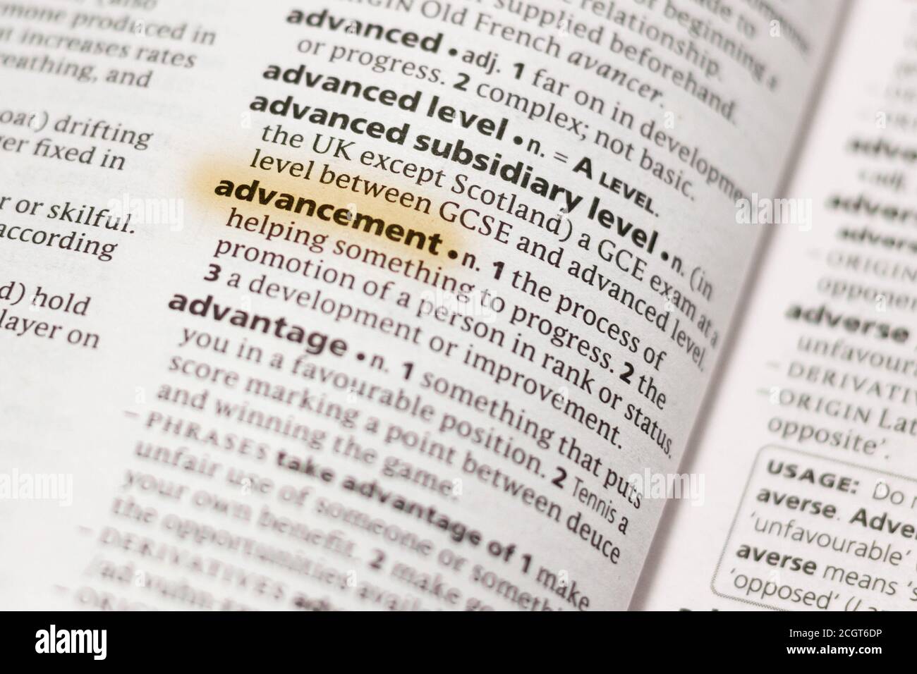 The word or phrase Advancement in a dictionary highlighted with marker ...