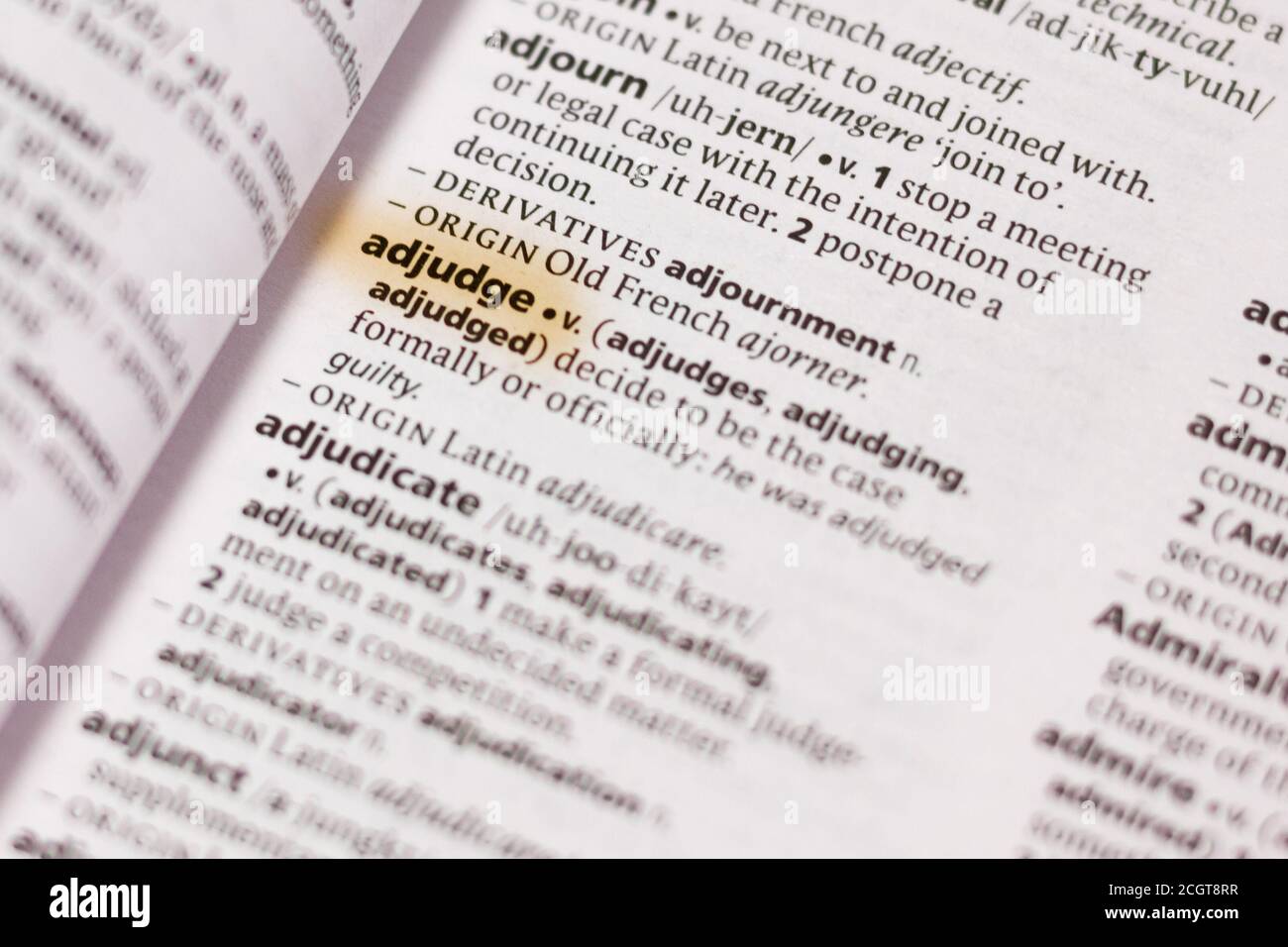 The word or phrase Adjudge in a dictionary highlighted with marker ...