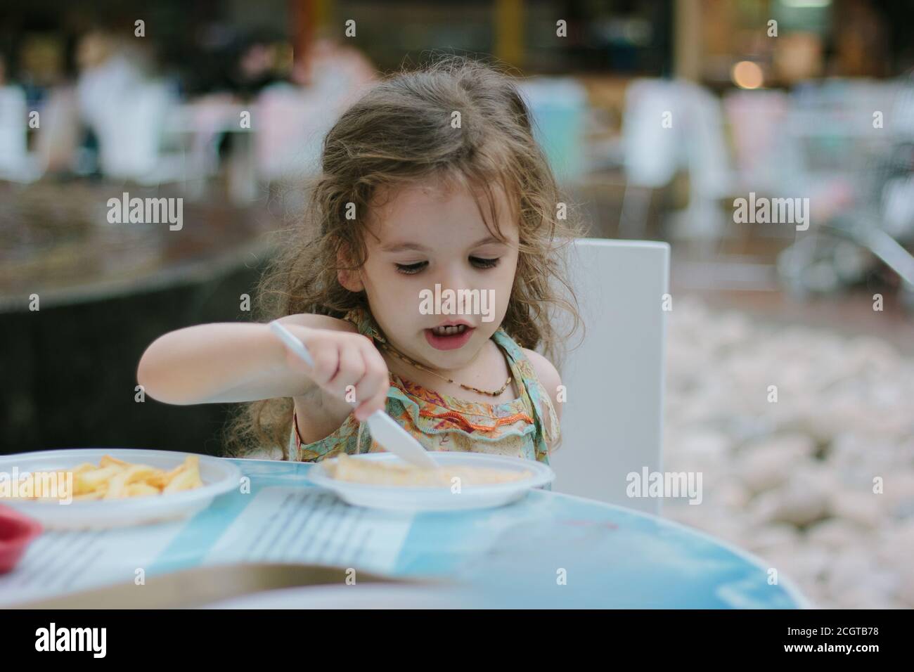 Little kid girl eating at the fast food restaurant Stock Photo - Alamy