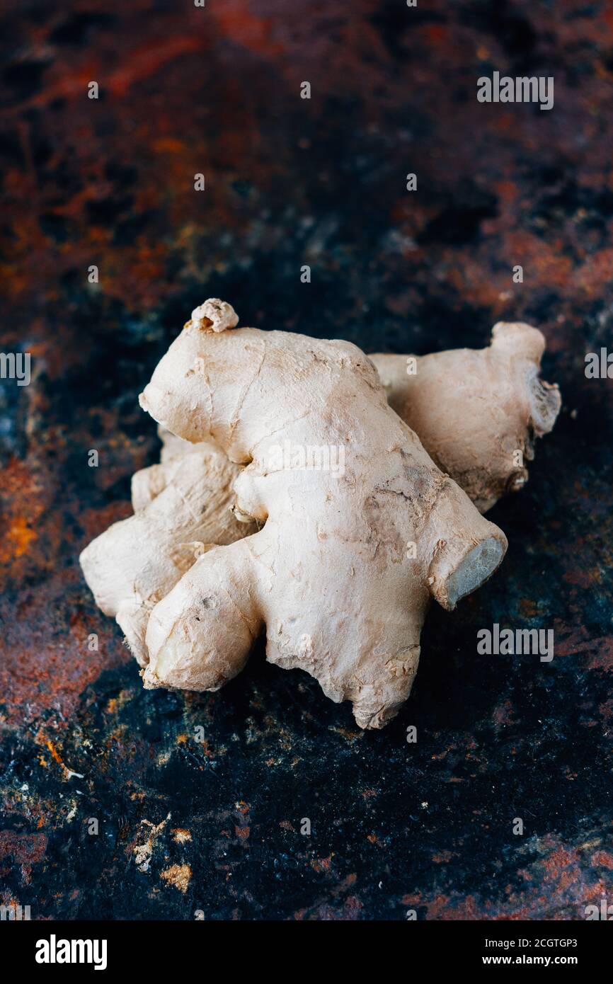 Organic ginger root on black rustic surface Stock Photo - Alamy