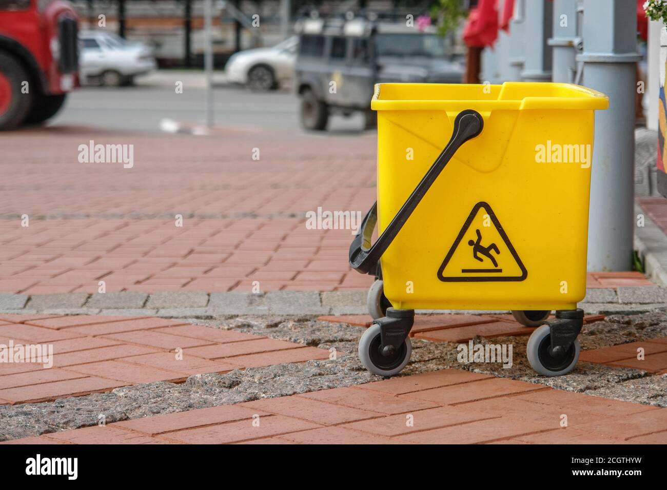 Yellow plustic bucket on street on brick pavement, outdoors Stock Photo ...