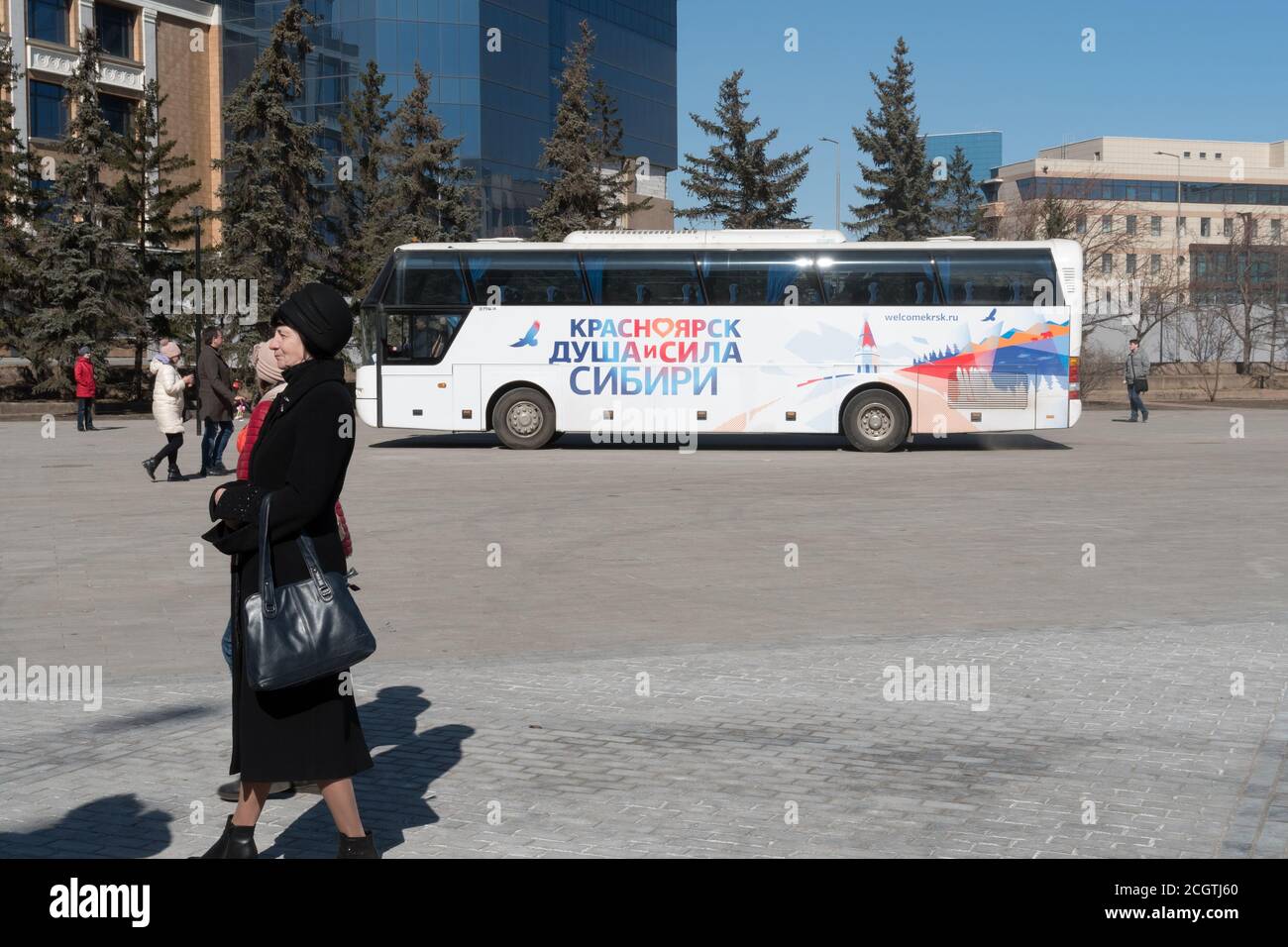 An elderly woman is waiting for a two-story tour bus with the ...