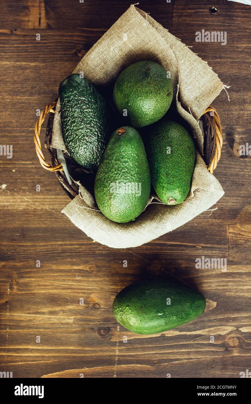 Avocado fruits in basket on wooden rustic background Stock Photo - Alamy