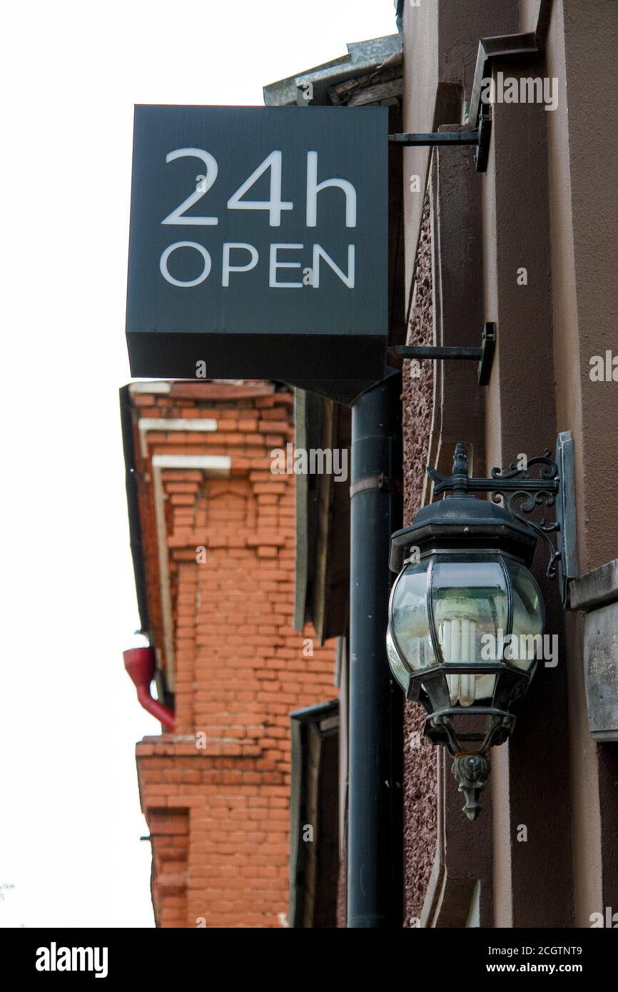 24 hours open signboard on a street on wall of store or resraurant ...