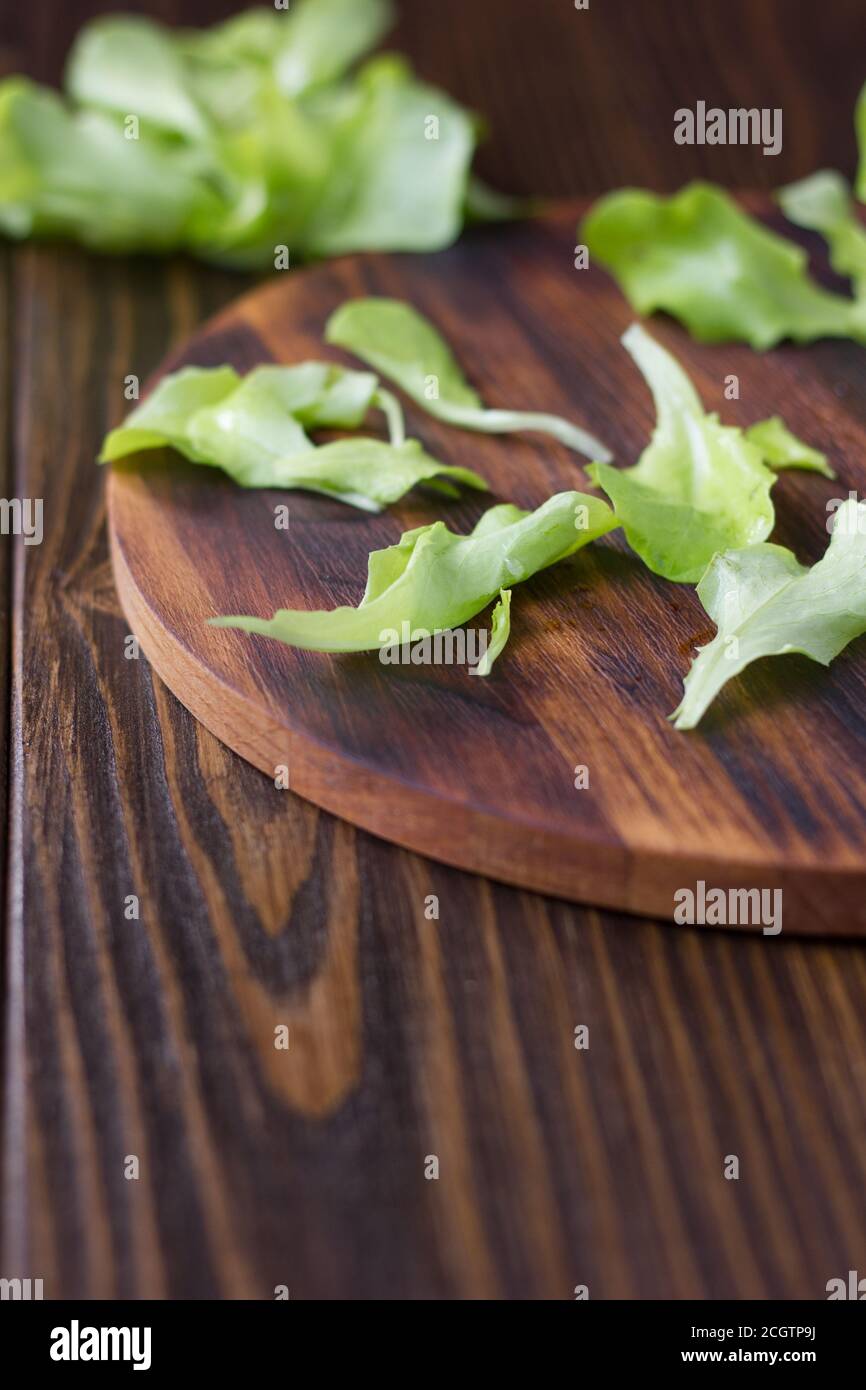 Green salad leaves on wooden board over table Stock Photo - Alamy