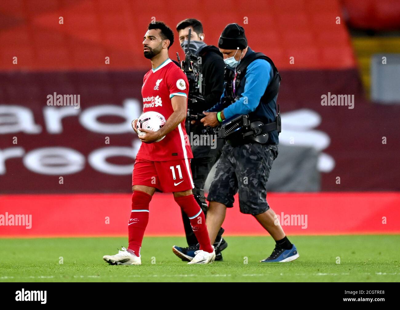 Liverpool's Mohamed Salah (left) leaves the pitch with the match ball ...